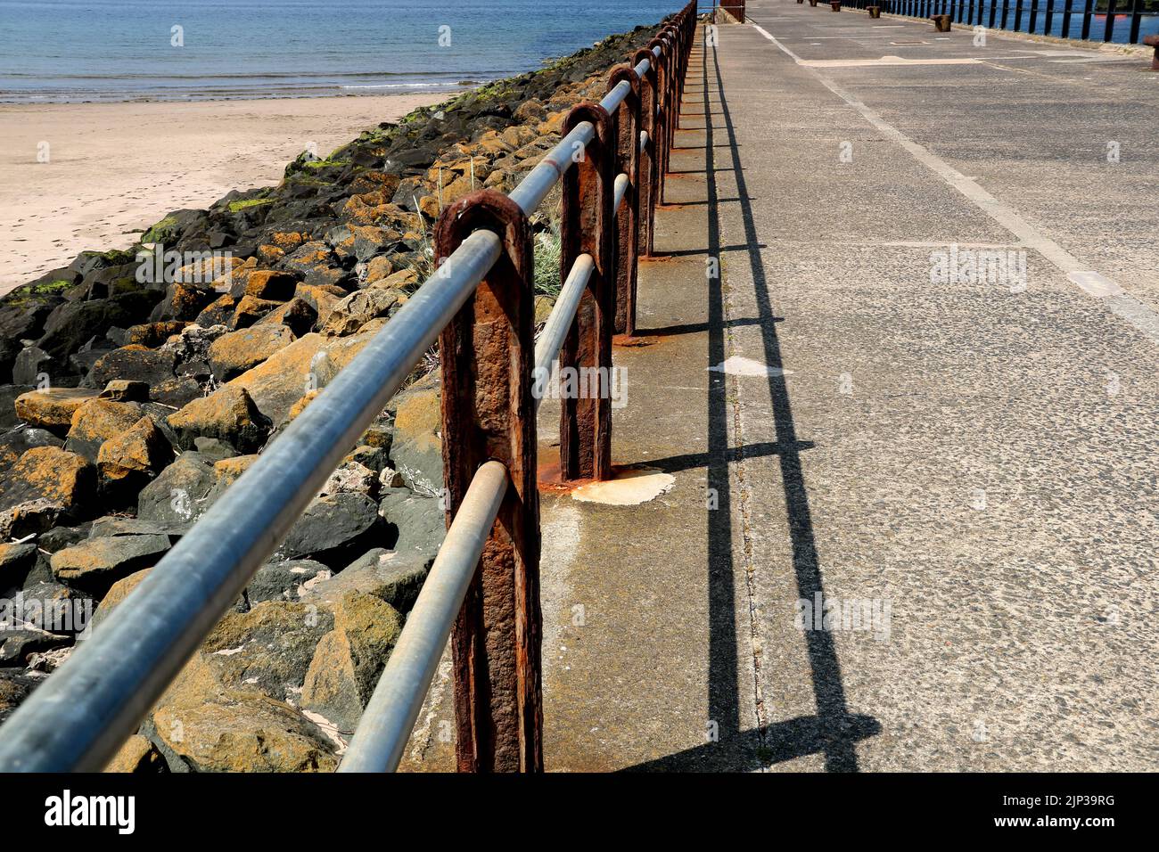 Jetty with handrail and rocks at a coastal location Stock Photo - Alamy