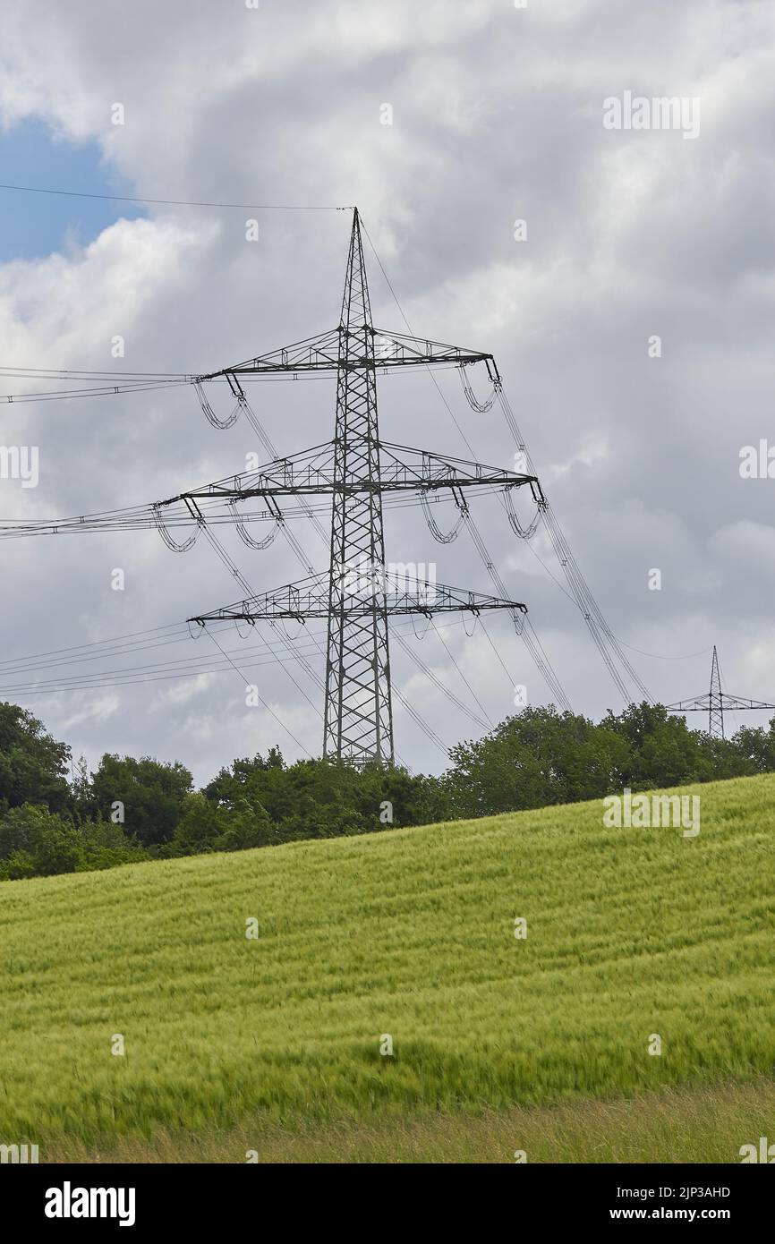 A vertical shot of a power grid transmission infrastructure on a green ...