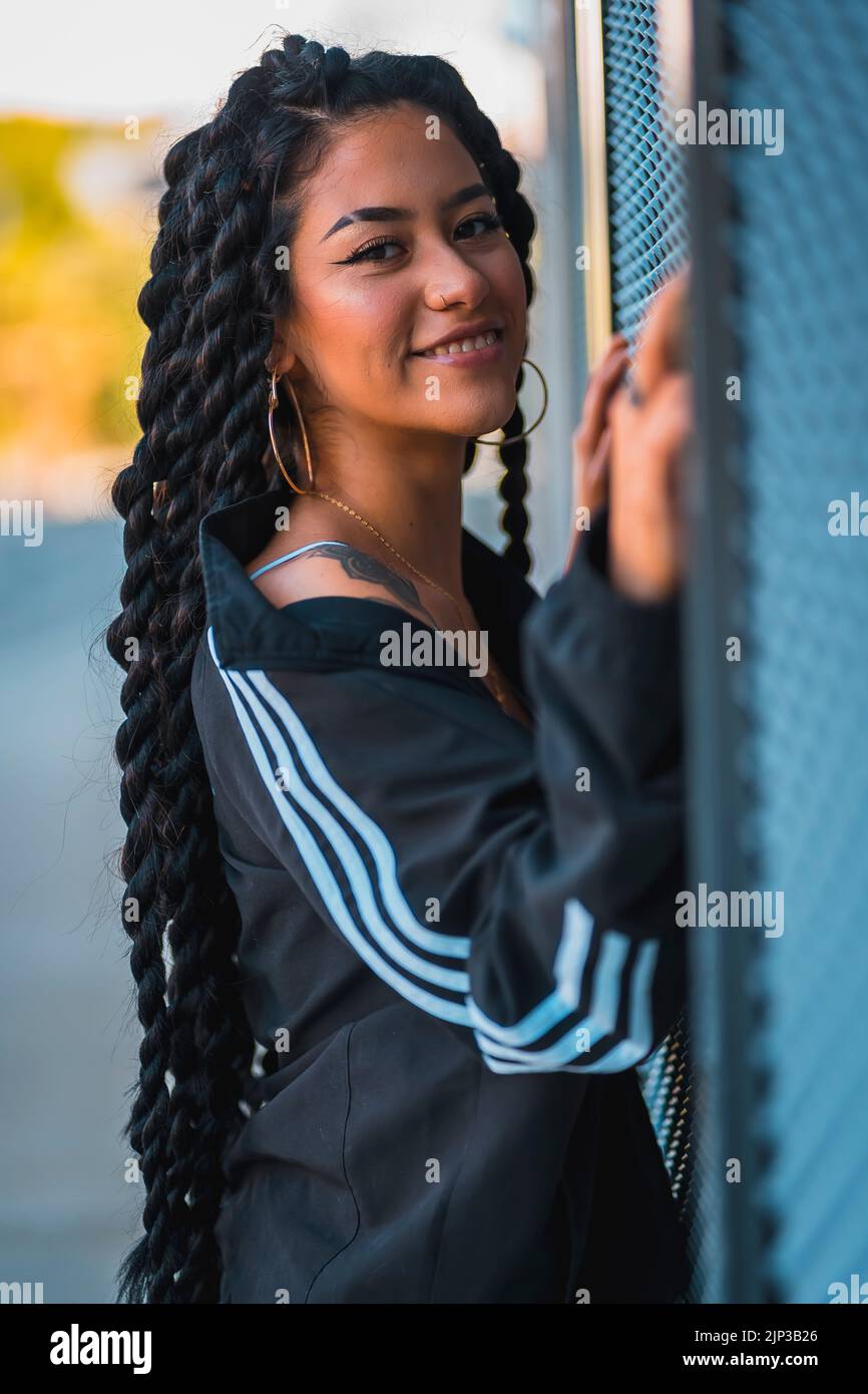 A Hispanic woman with long braids smiling Stock Photo - Alamy