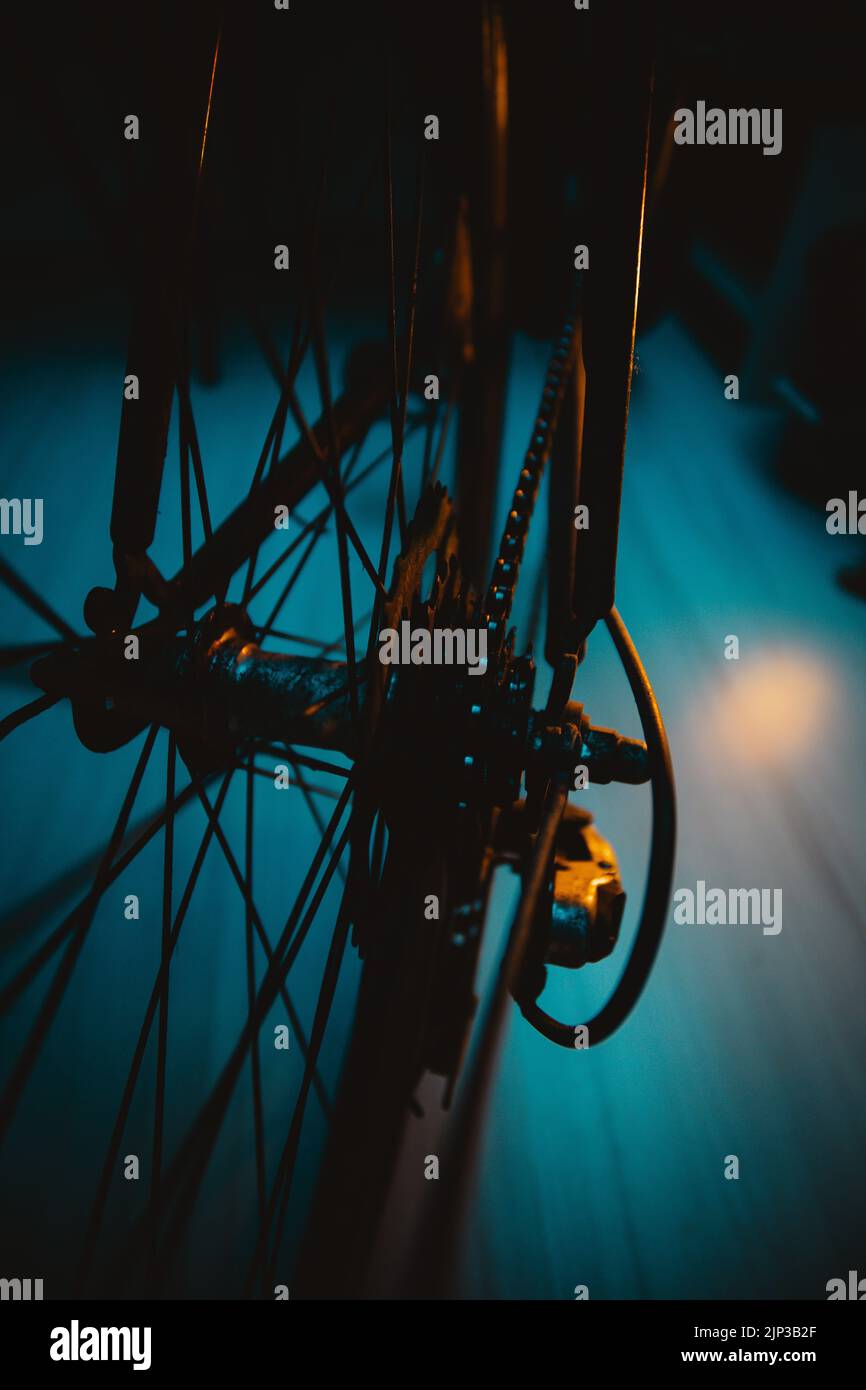 A vertical shot of a bicycle wheel in motion on a blurry background ...