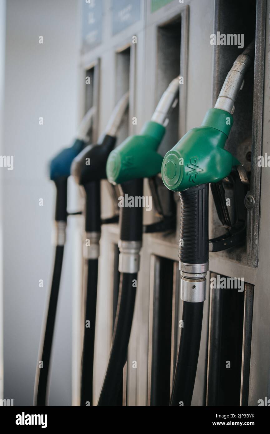 A vertical closeup gas pistols at gas station Stock Photo - Alamy