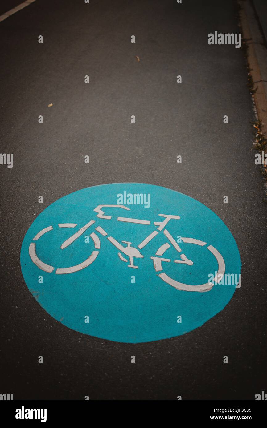 A vertical shot of a bike lane with a blue circle and white bicycle ...