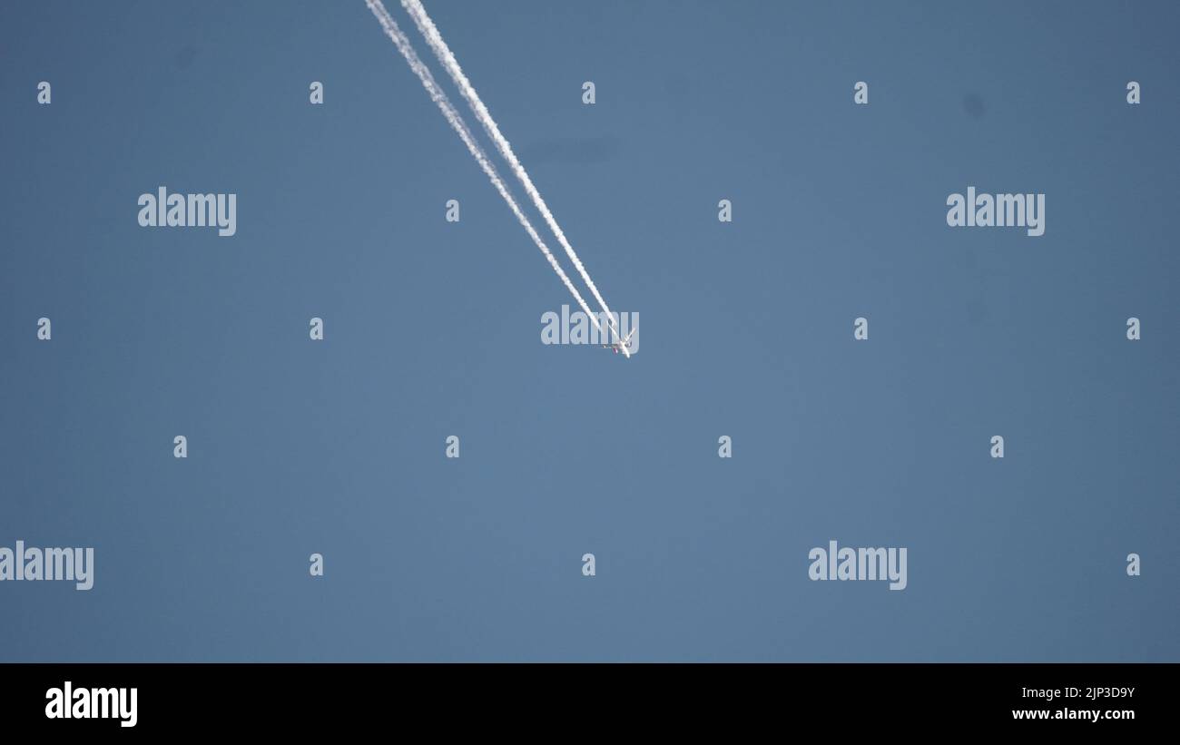 airplane midair with contrails Stock Photo - Alamy