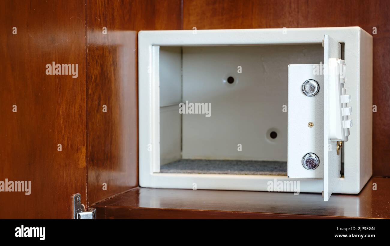 Security open metal safe with empty space inside in a wooden shelf ...