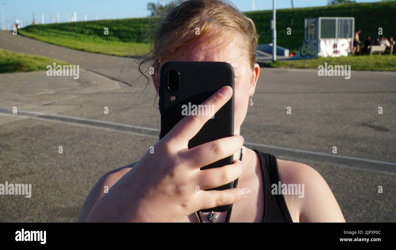 girl hold her phone in front of face Stock Photo - Alamy