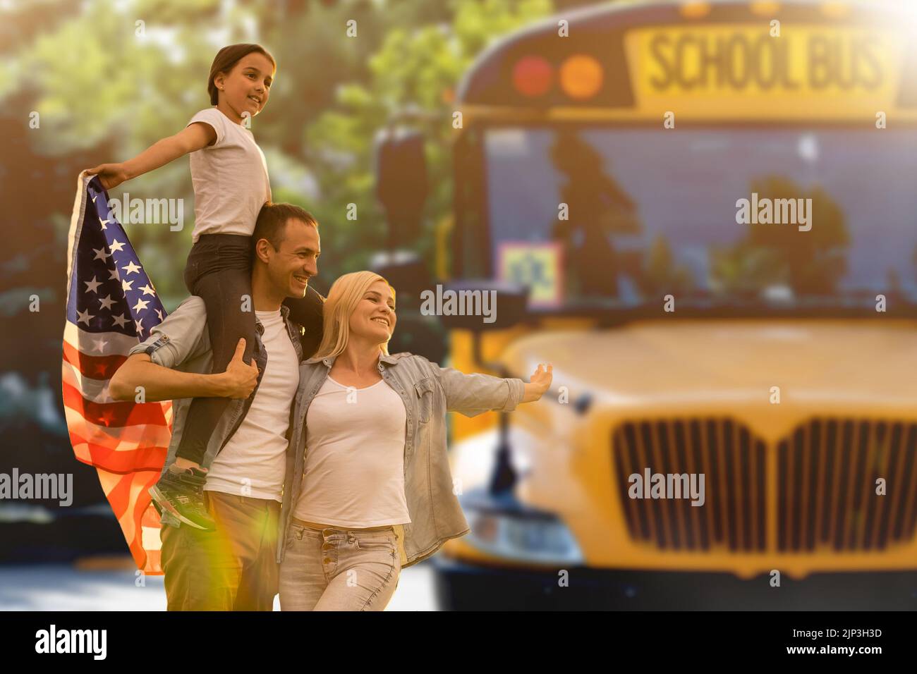 Happy young family with national flags of USA near the school bus Stock ...