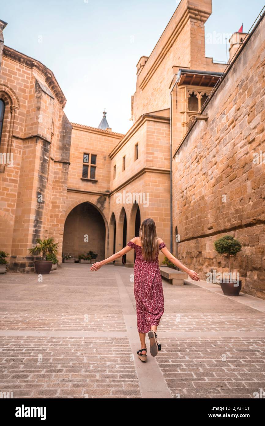 A blonde Caucasian girl walking in a medieval castle - vertical shot ...