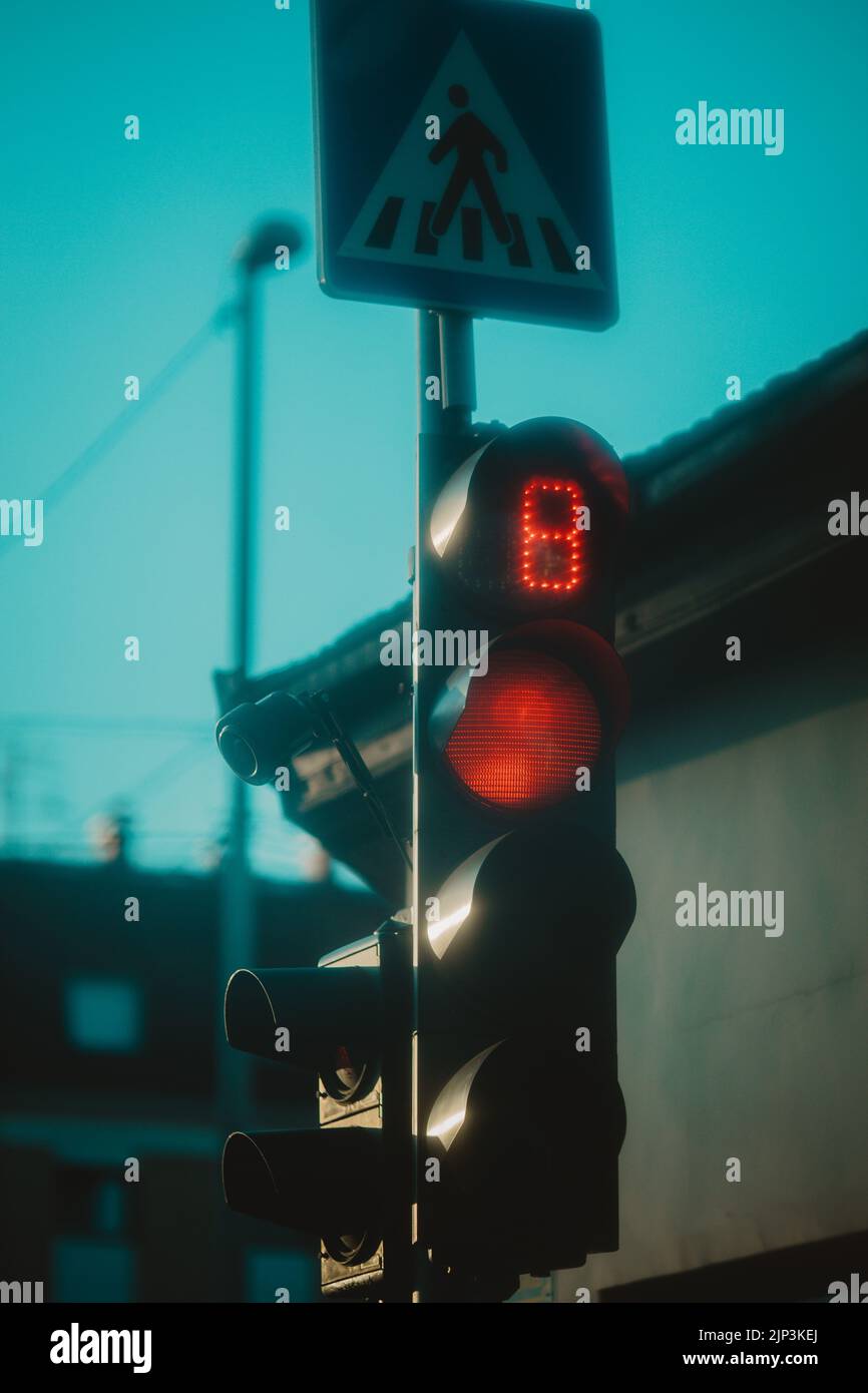 A vertical shot of traffic light pole with the red light and 8 seconds ...