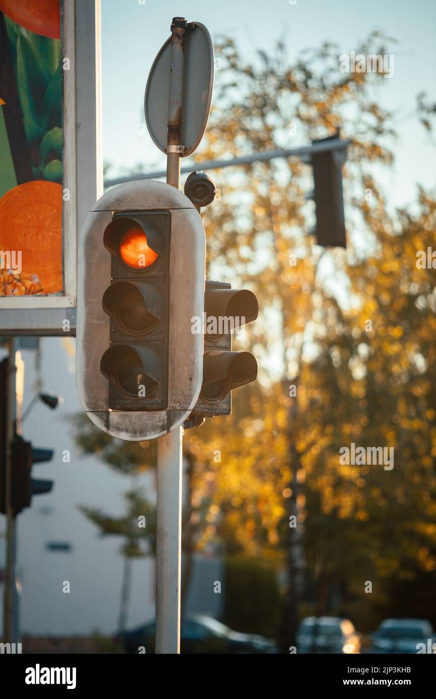 A vertical shallow focus shot of traffic light pole with the red light ...