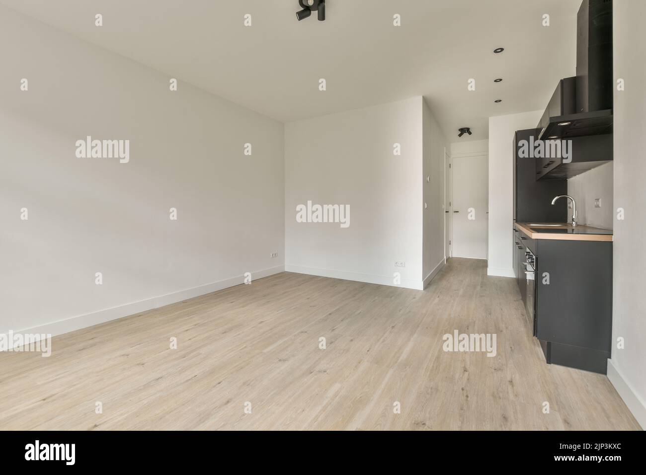 Interior of empty white kitchen with windows and wooden parquet floor ...