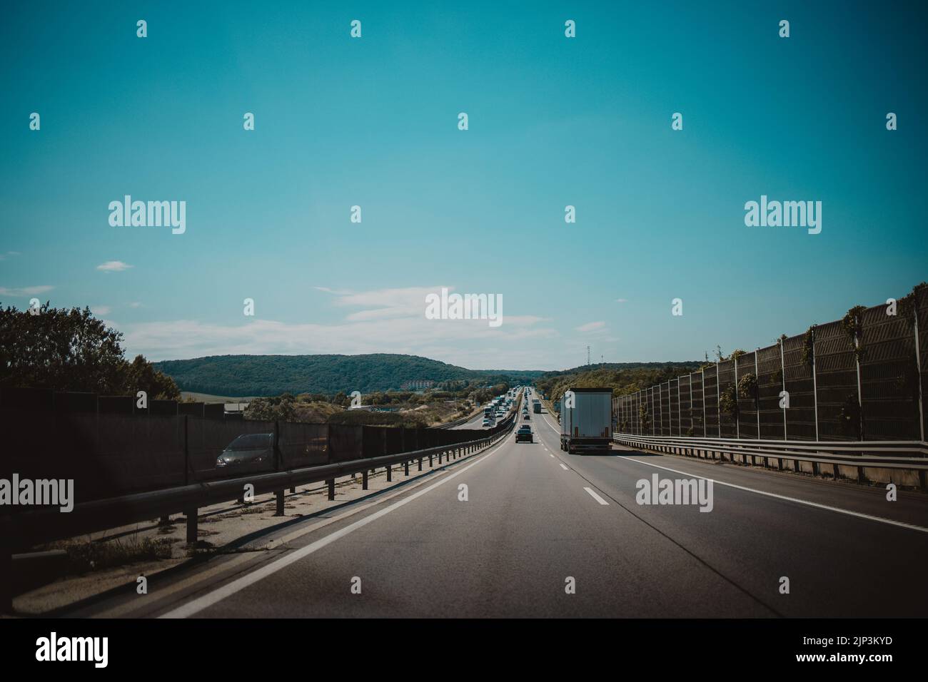 A highway traffic in Vienna, Austria with blue sky background trees ...