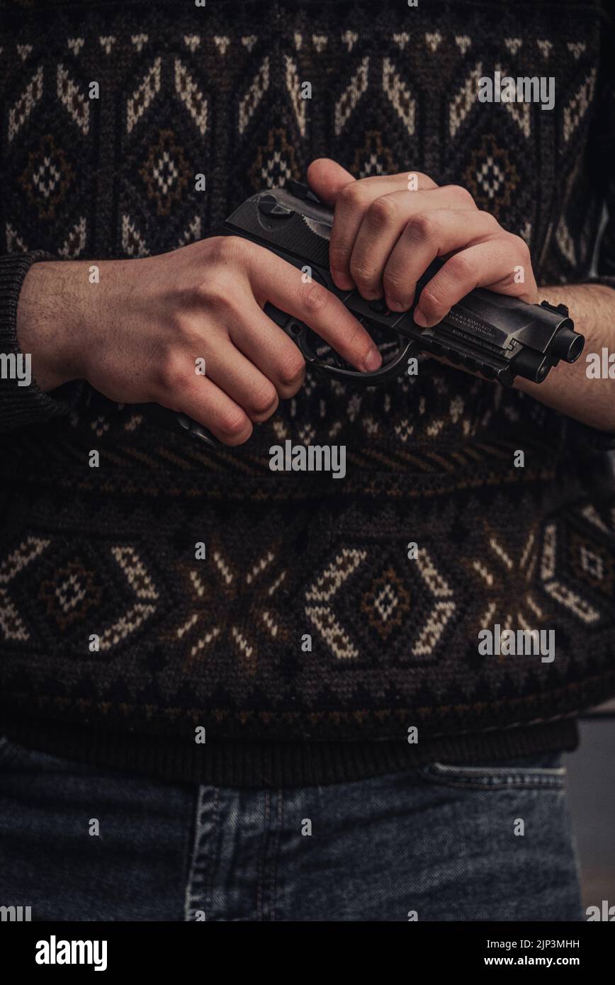 The man prepares to load the gun while touching the trigger Stock Photo ...