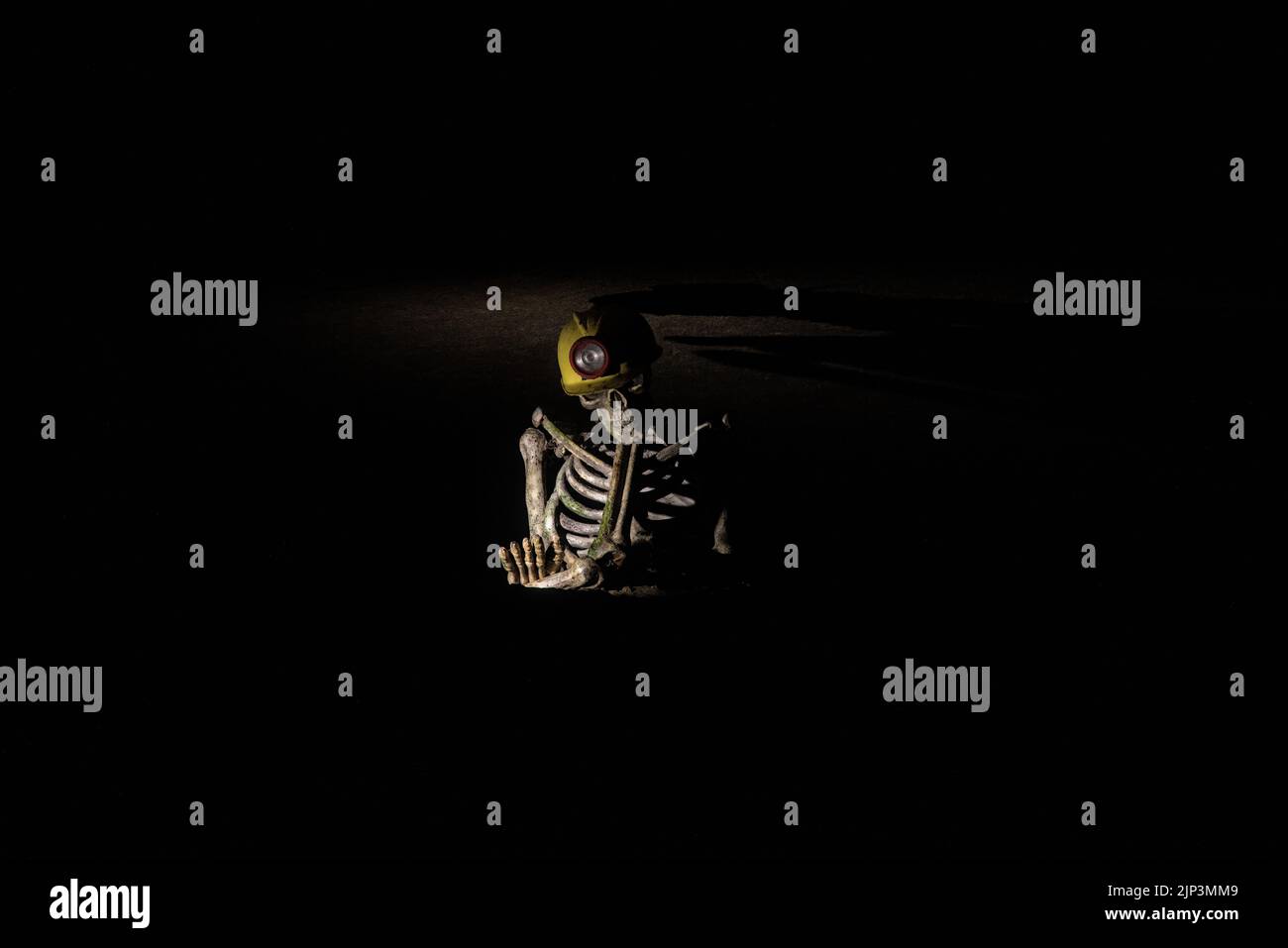 A skeleton of a cave miner with a headlamp in the dark - great for ...