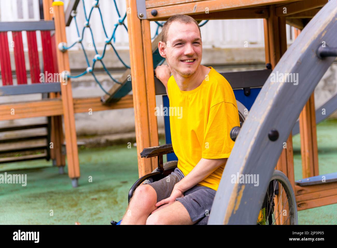 A disabled person in a wheelchair on the swings of a playground Stock ...