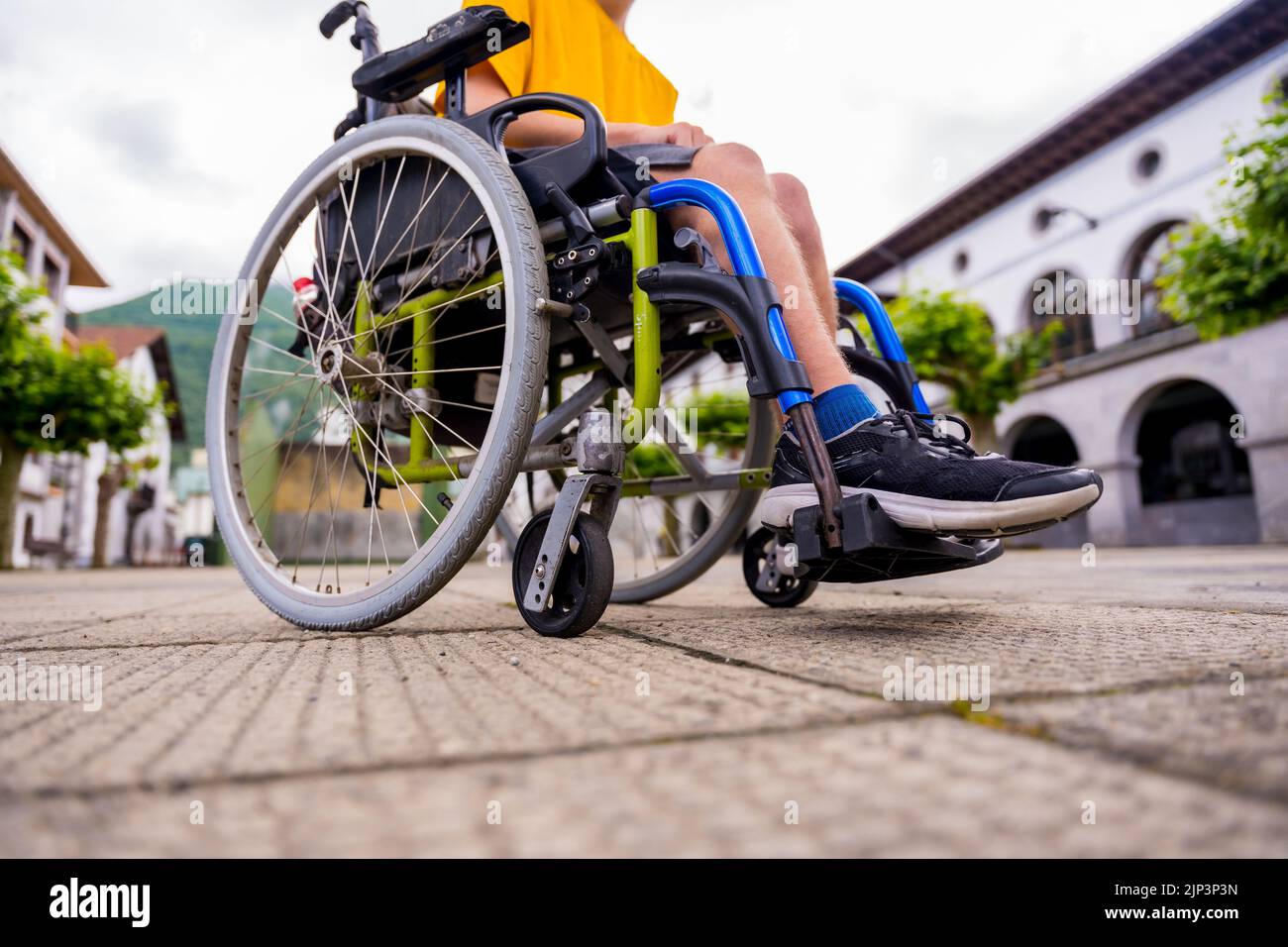 A disabled person in a wheelchair walking through the town square Stock ...