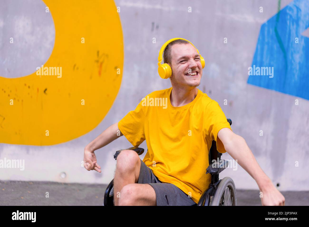 The disabled person in a wheelchair listening to music with headphones ...