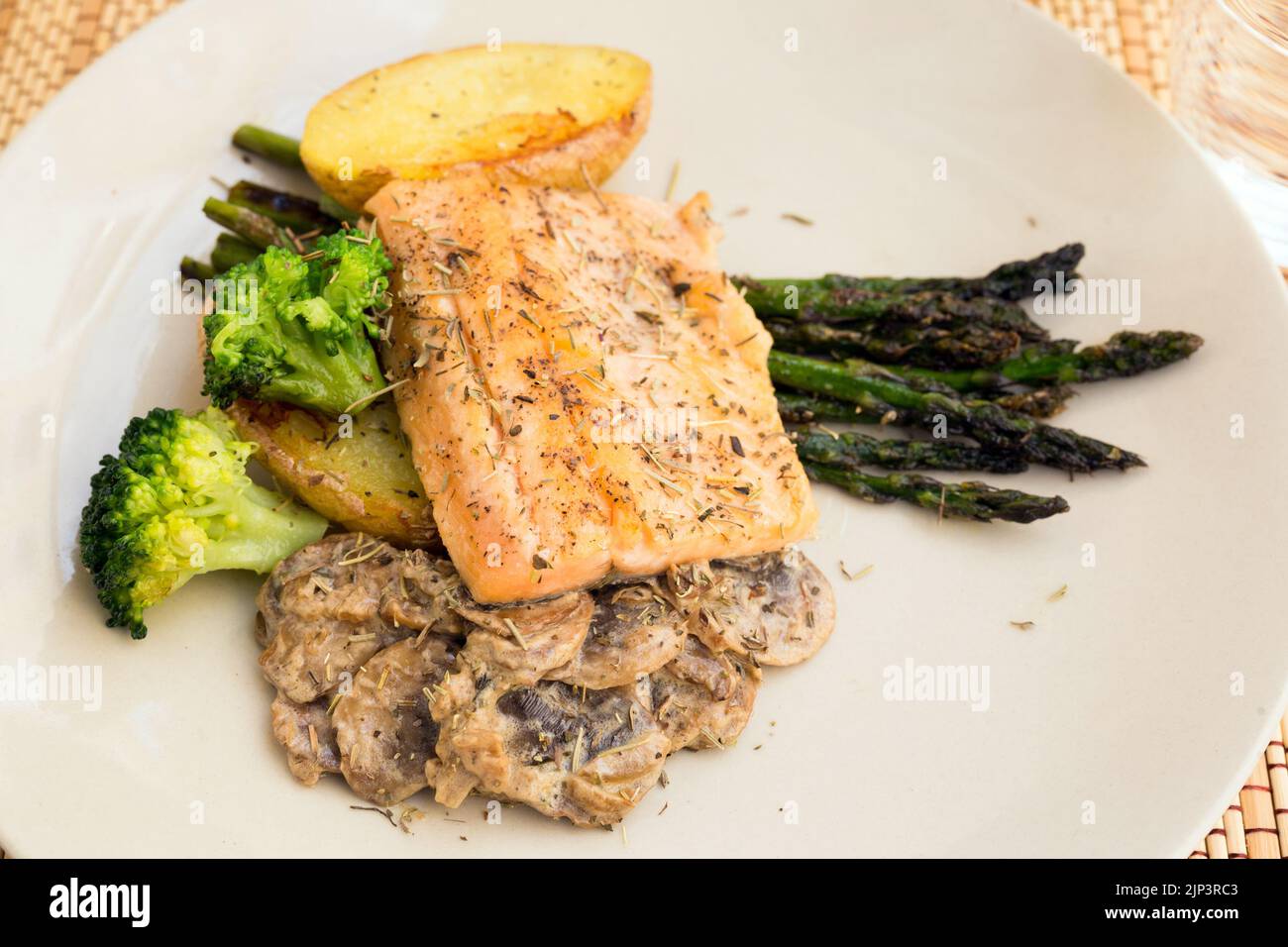 dish of fried river trout fillet with garnish of broccoli, asparagus ...