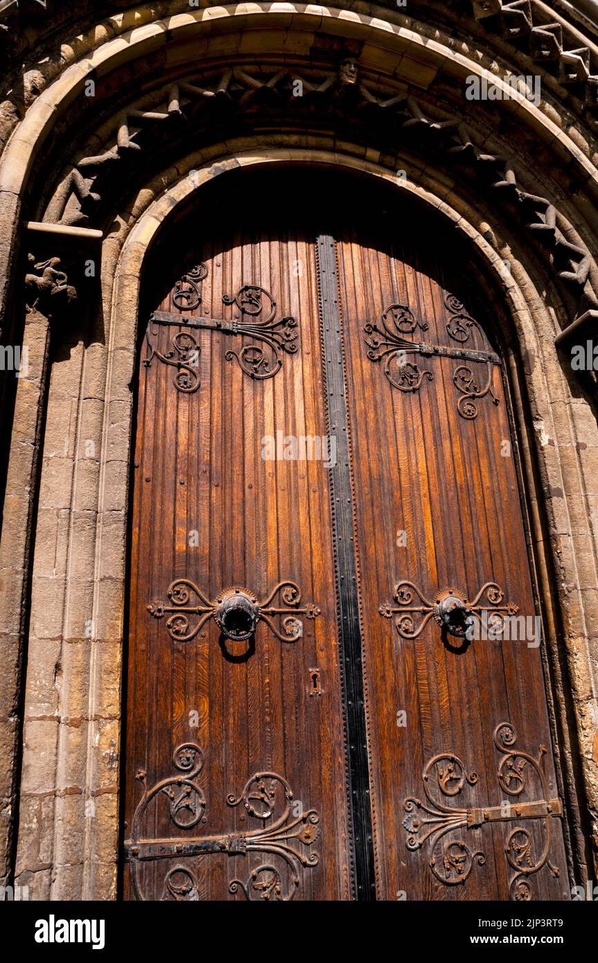 Carved stone arch and rusted iron hinges on the Romanesque portal of ...