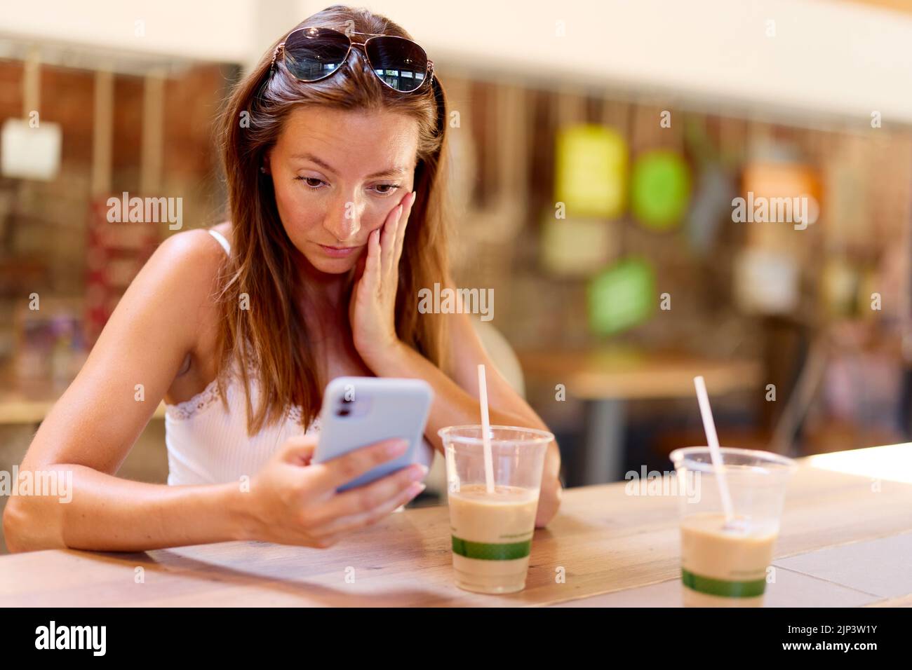 Woman looking shocked looking at message Stock Photo - Alamy