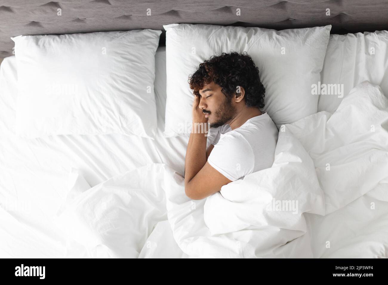 View above of eastern guy sleeping alone in bed Stock Photo - Alamy
