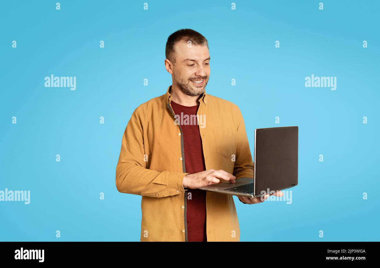 Successful Freelancer Male Using Laptop Computer Over Blue Studio ...