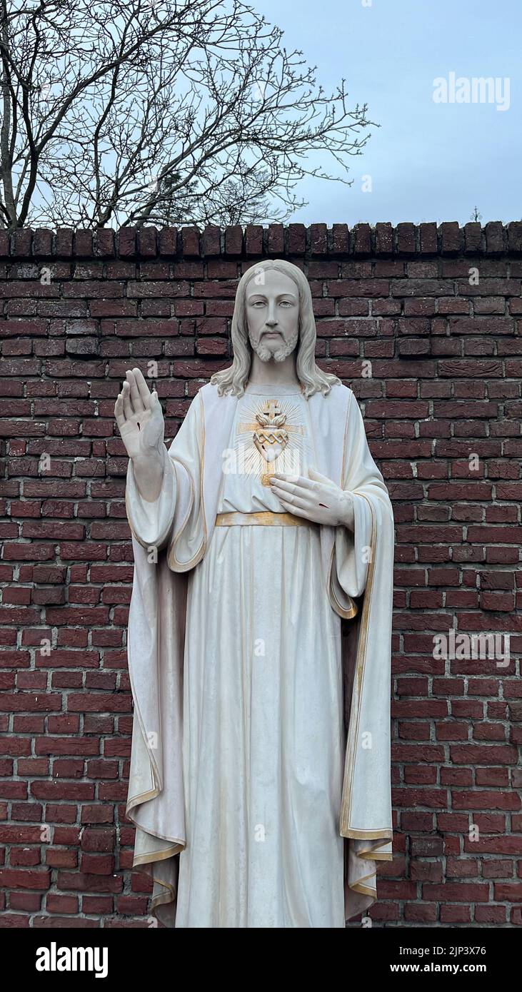 A vertical shot of a white marble statue of Jesus Christ against the ...