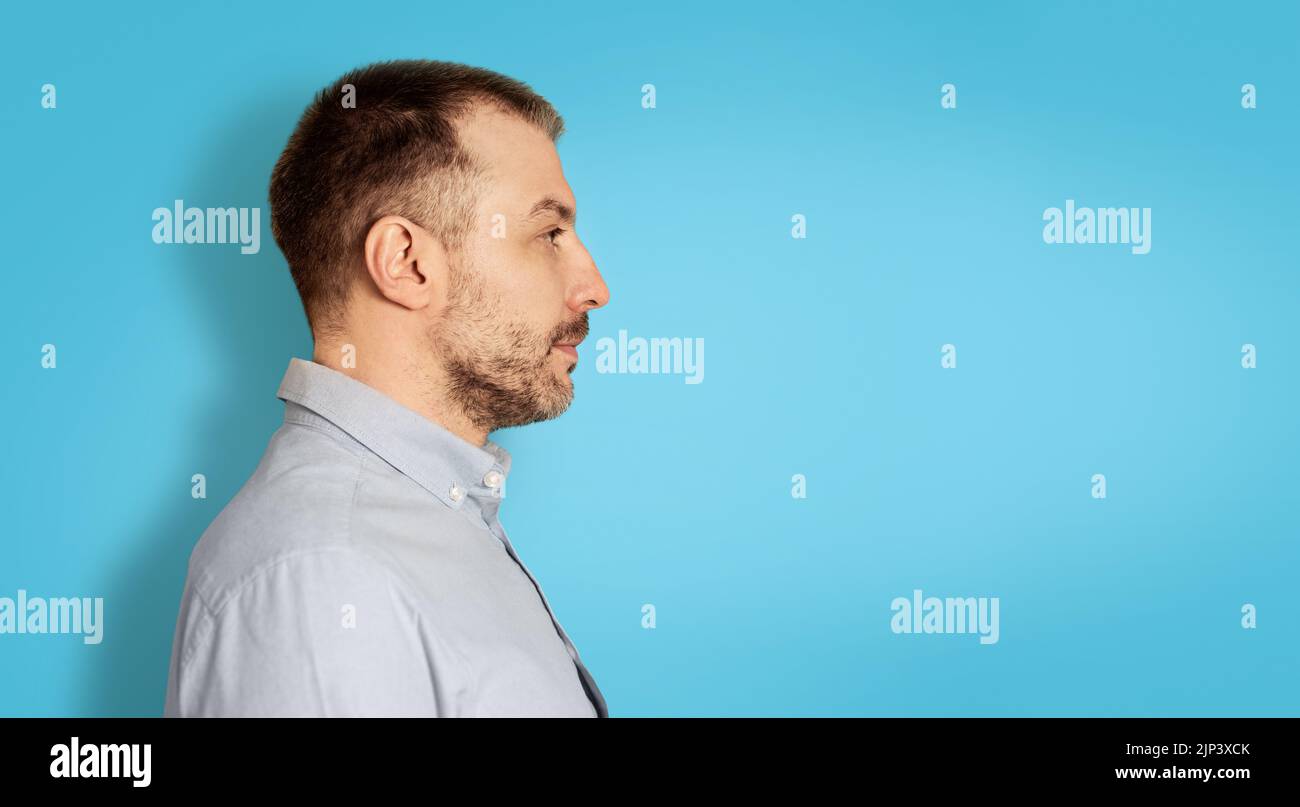 Serious Middle Aged Man Looking Aside, Blue Background, Side View Stock ...
