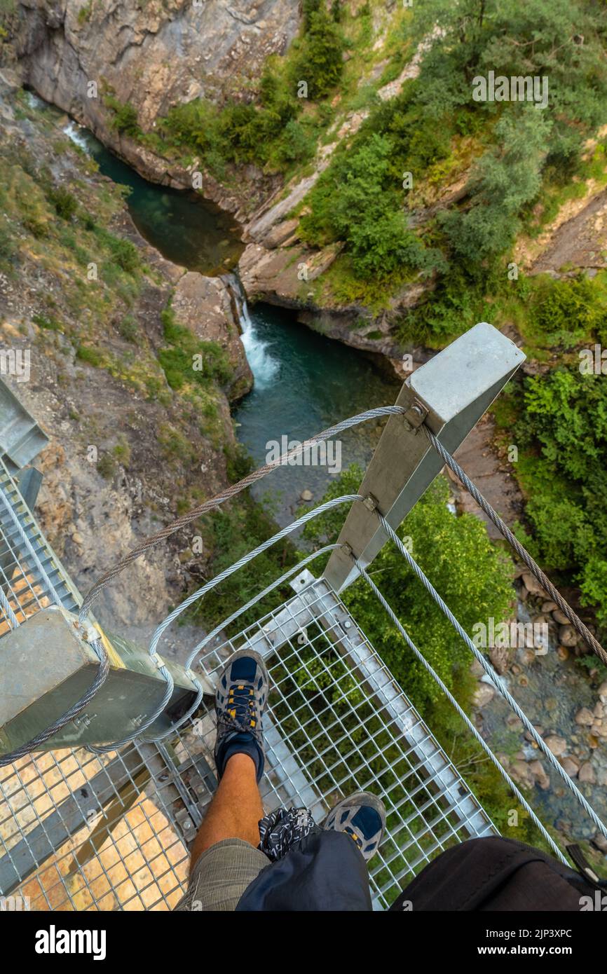 A vertical shot from a metallic bridge of a river between cliffs Stock ...
