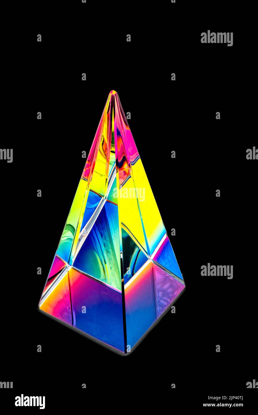 Glass pyramid prism with colorful light reflection on black background ...