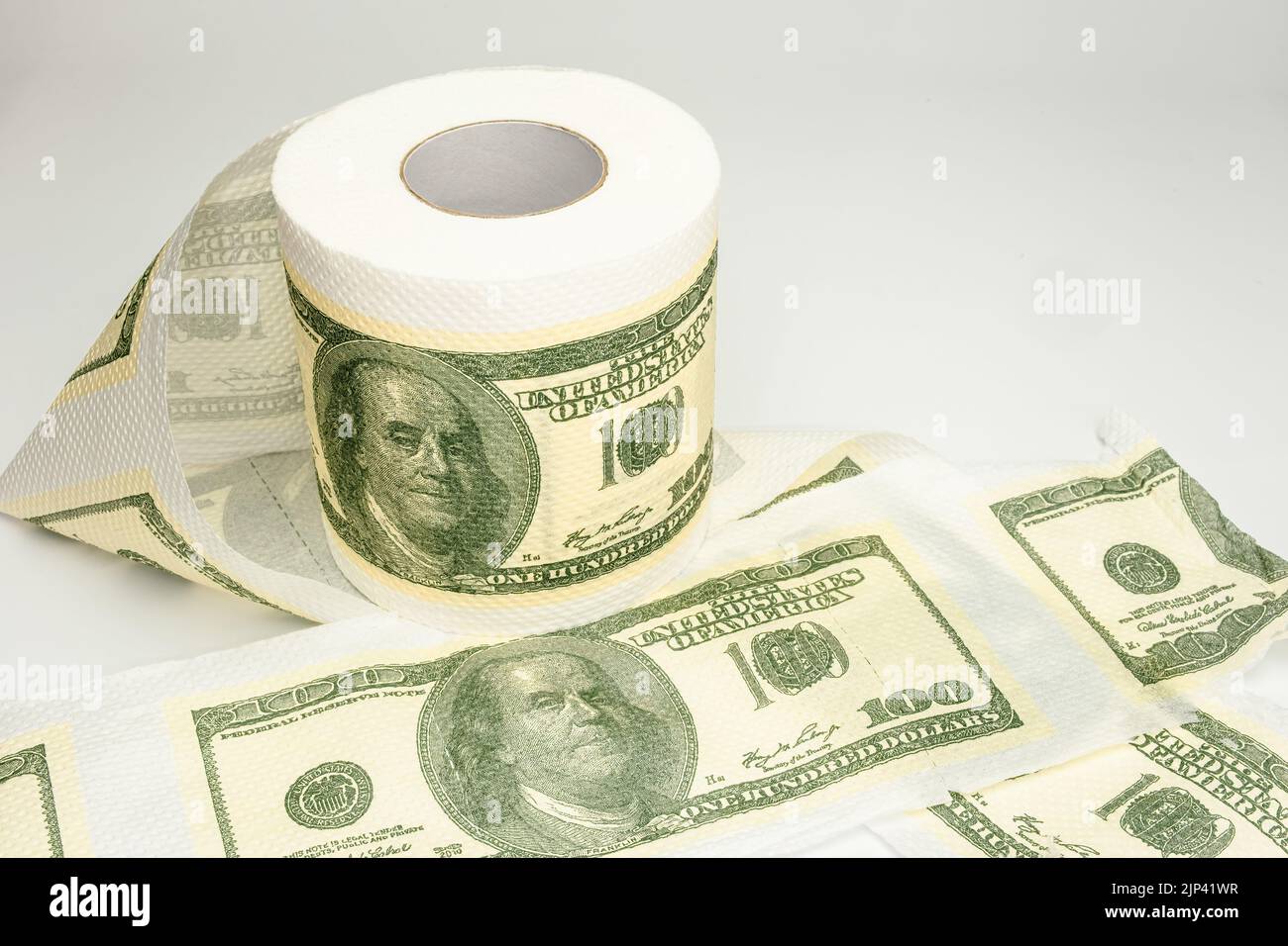 Rolls of bank notes toilet paper on white background Stock Photo - Alamy