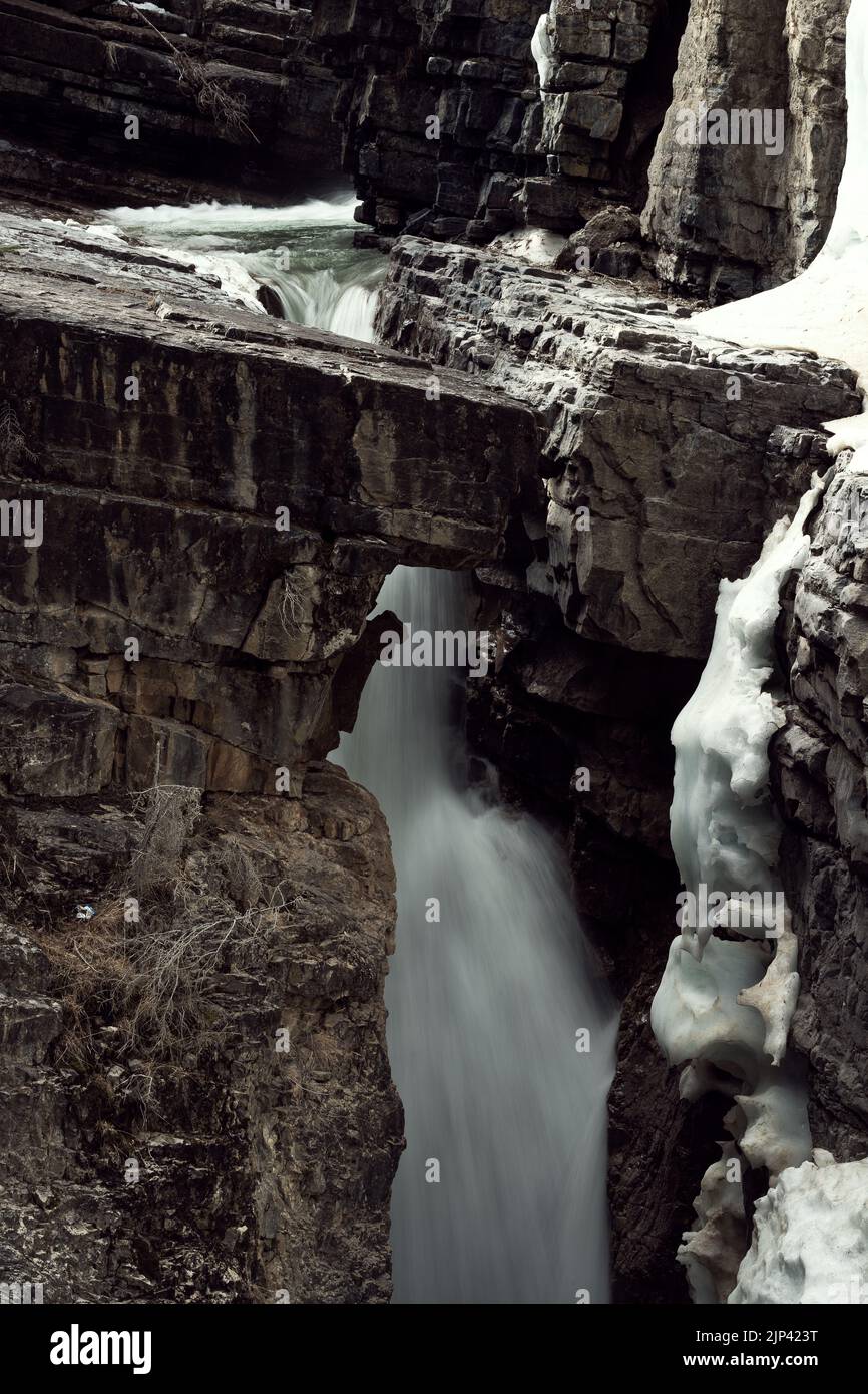 Beautiful vertical shot of a waterfall from the middle of cliff in ...