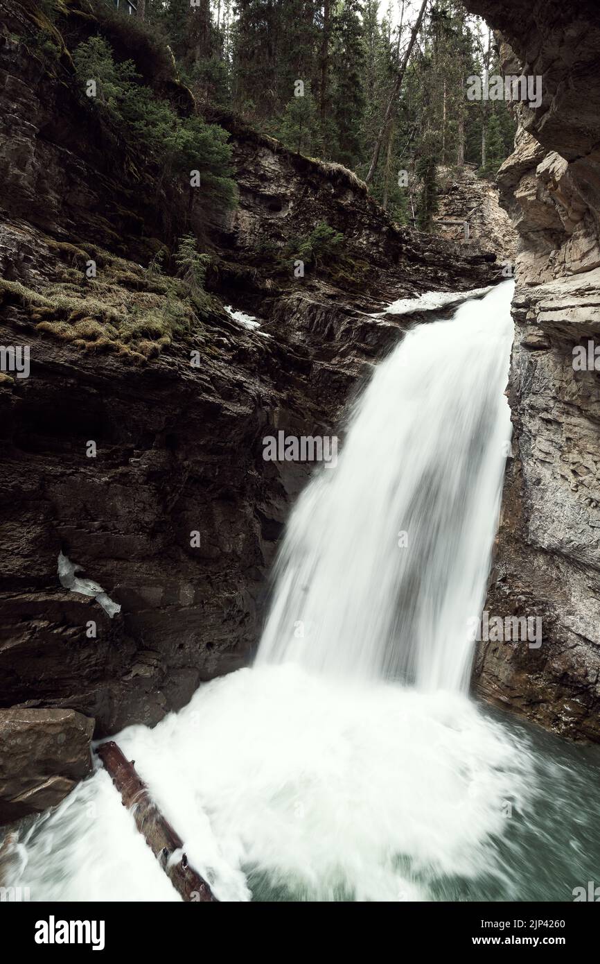 Beautiful vertical shot of a waterfall from the middle of cliff in ...