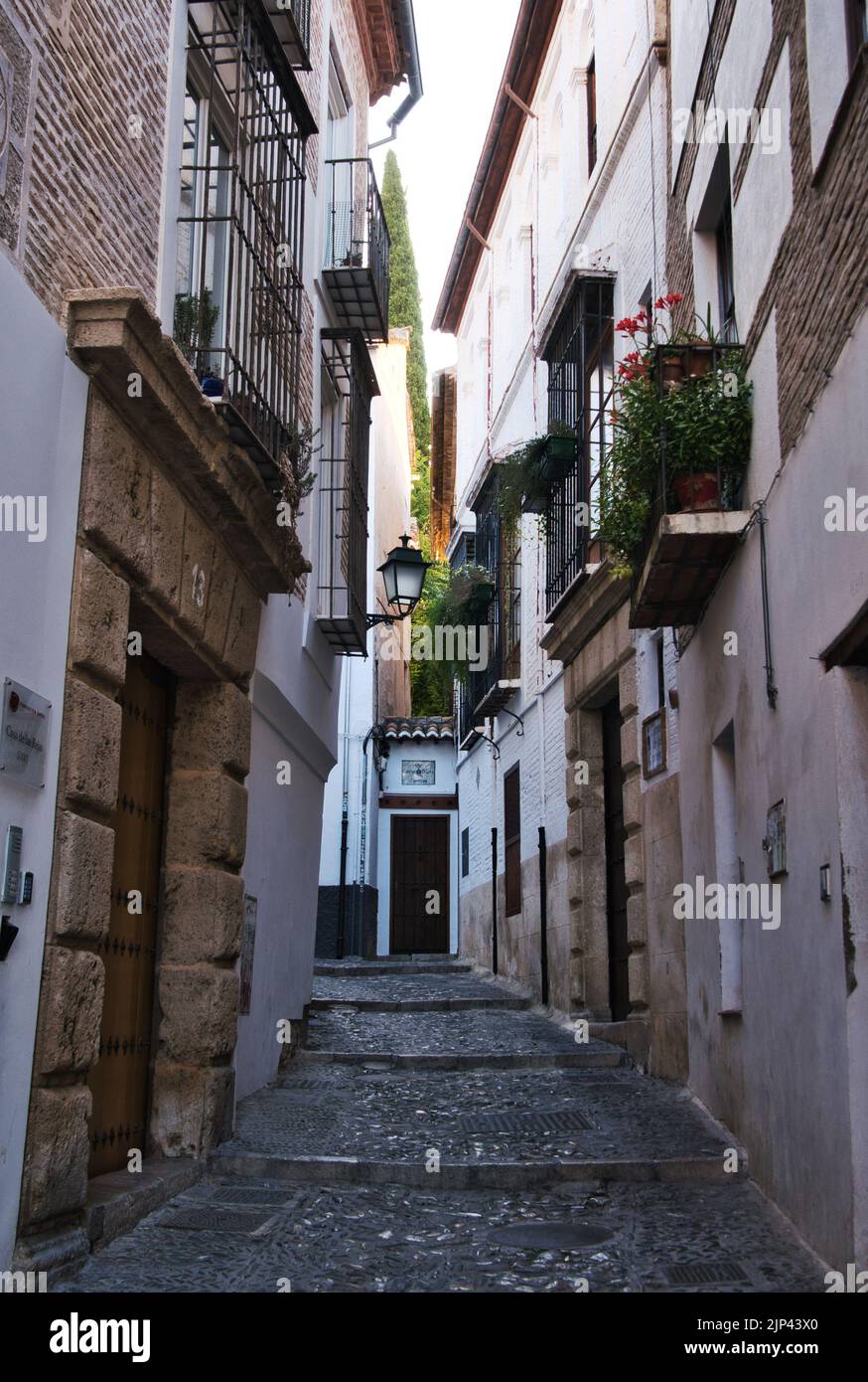 A vertical of narrow walkway in Granada, Spain with close residential ...