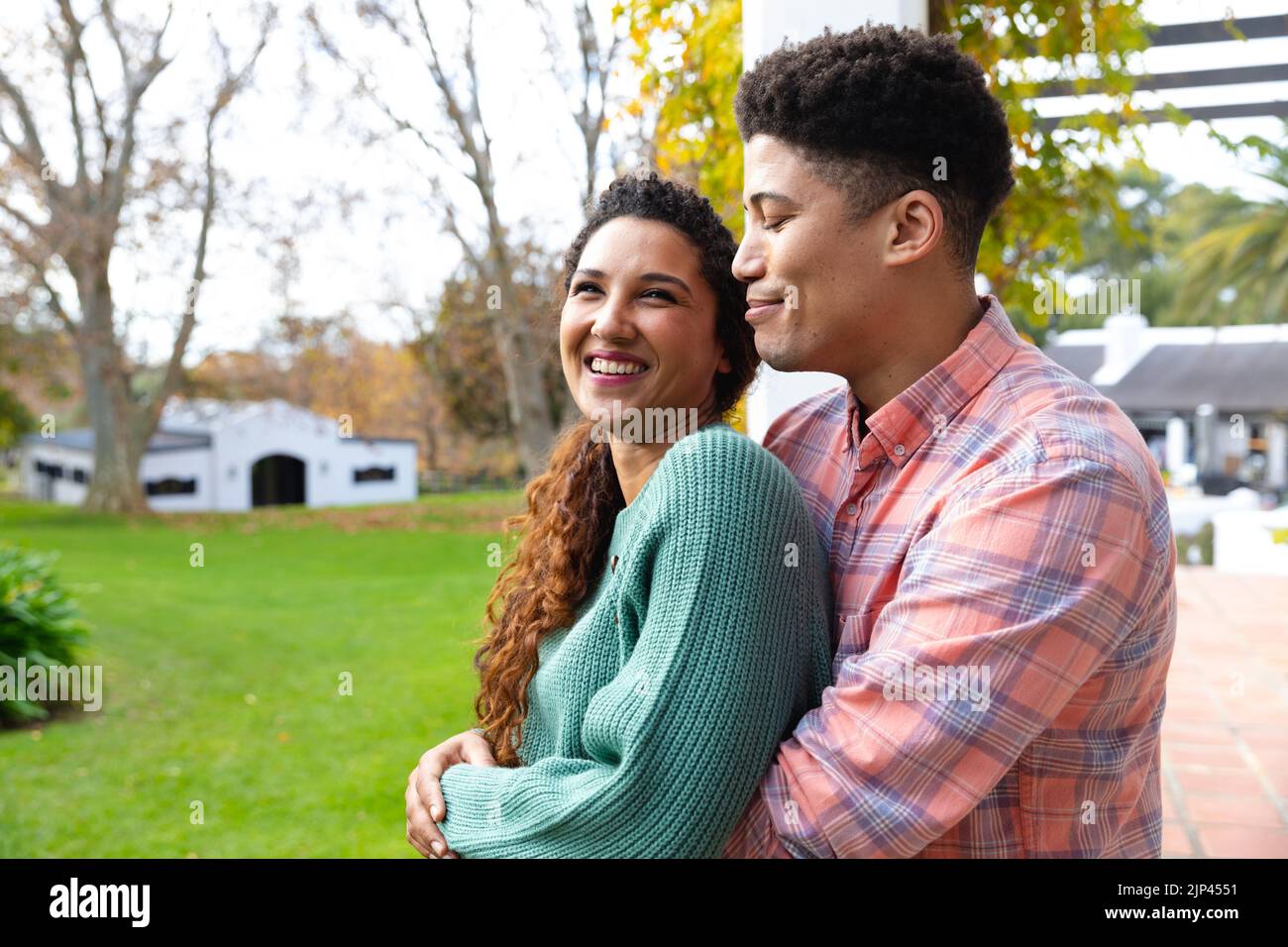 Happy biracial couple embracing and smiling on terrace in garden Stock ...