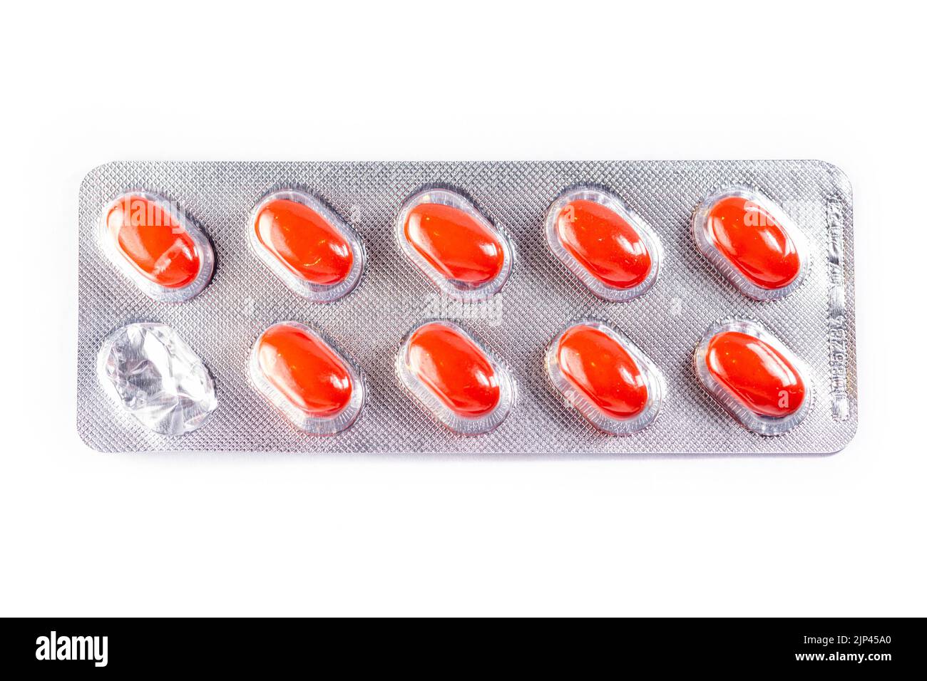 The red capsules in silver blister pack with one missing isolated on ...