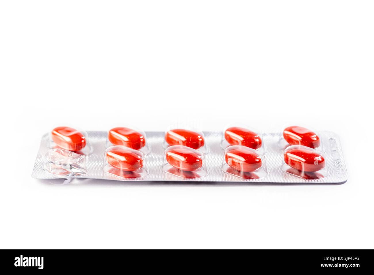 The red capsules in silver blister pack with one missing isolated on ...