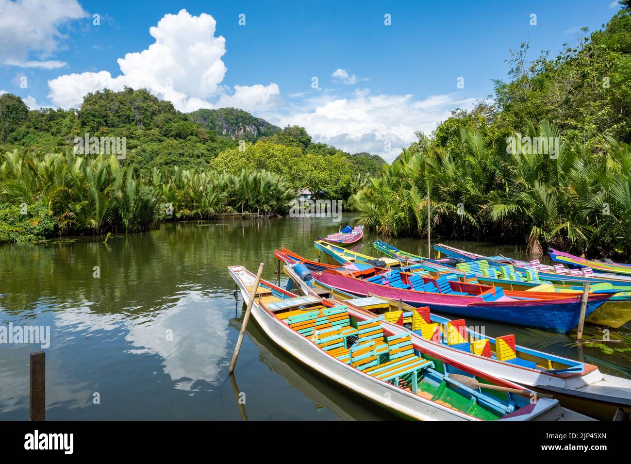 Colorfully painted boats in a river. Kampoeng Karst Rammang Rammang ...