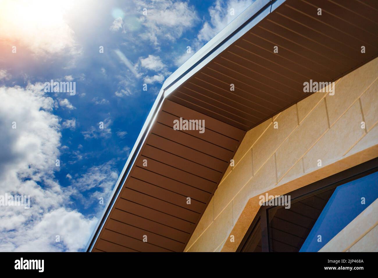 New roof with ridge, gable and cornice against the sky. Part of the ...