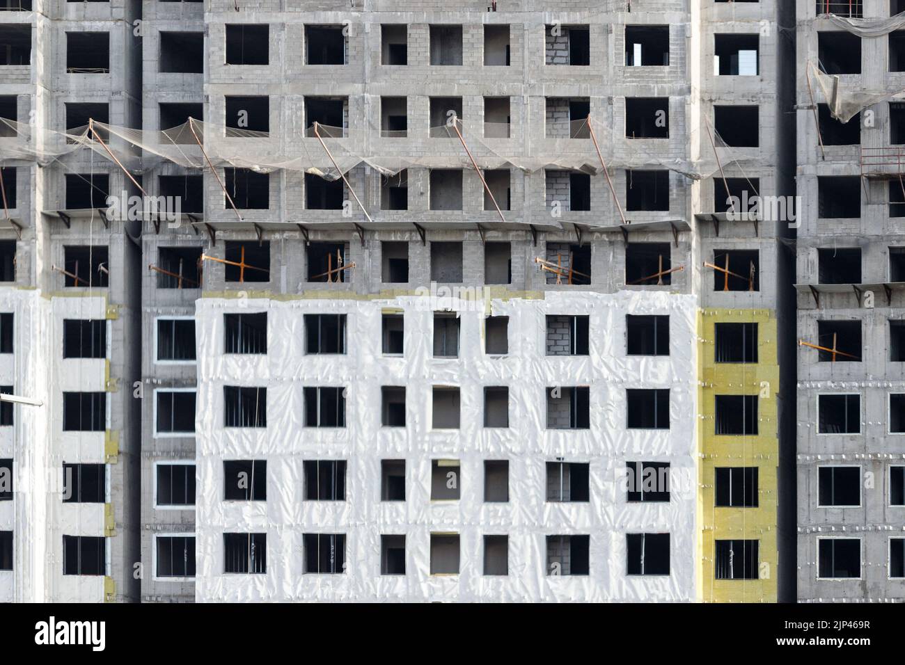 The facade of a new monolithic apartment building under construction in ...