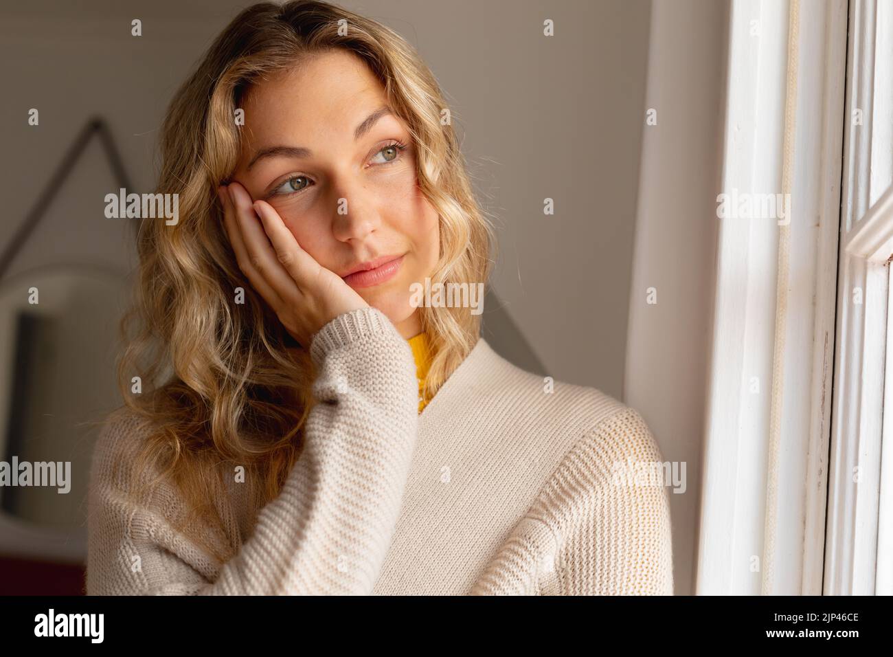 Woman smiling while looking outside through window