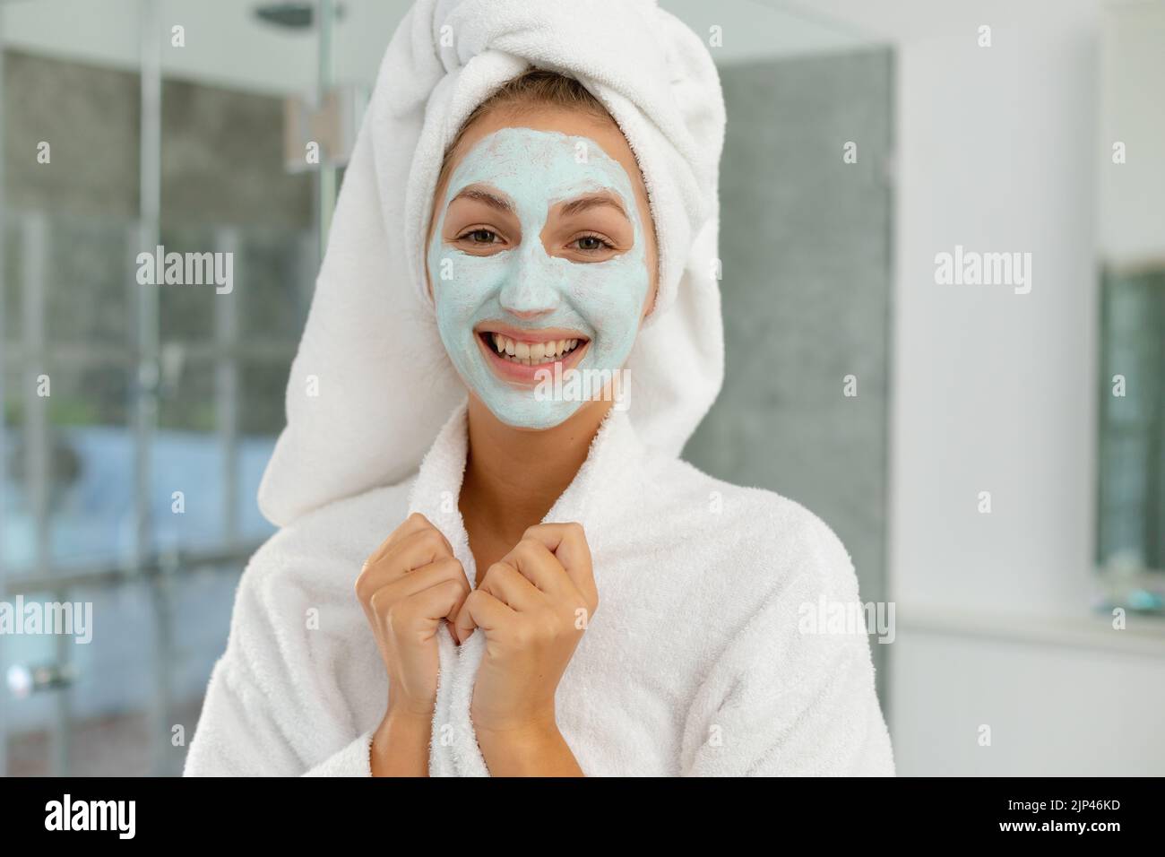 Portrait of happy caucasian woman wearing robe, applying beauty face ...