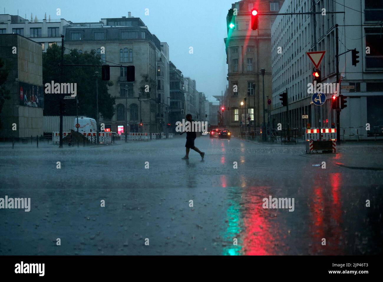 Berlin, Germany. 15th Aug, 2022. A man walks across an intersection in ...