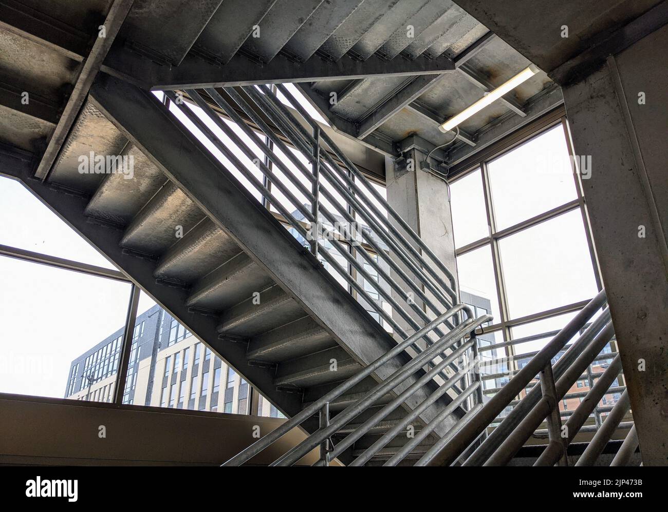 An indoor parking ramp stairwell with metallic stairs during daytime ...