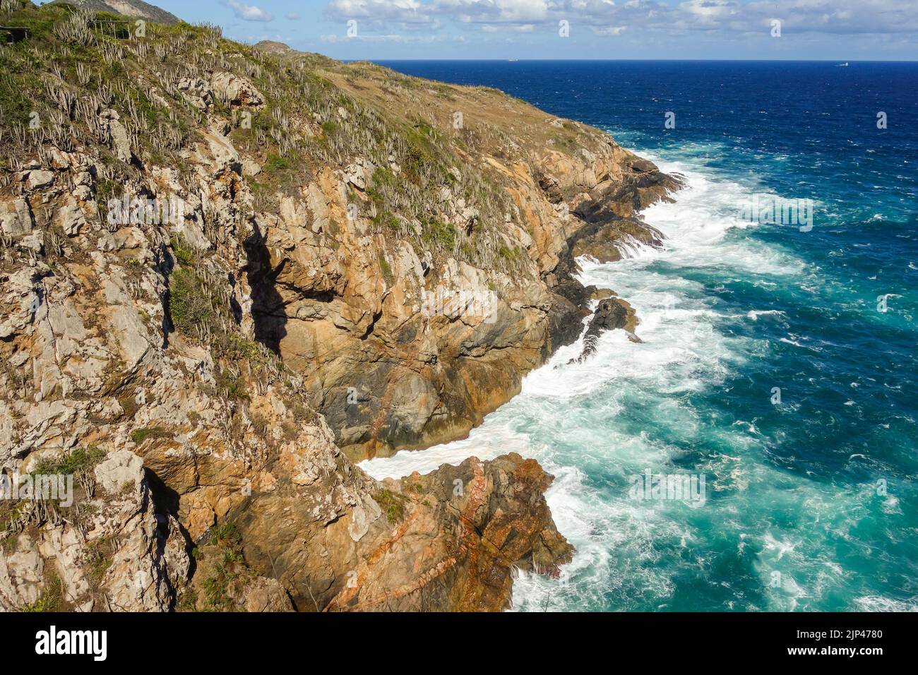 rough sea waters crash violently against rock cliff on the coast Stock ...