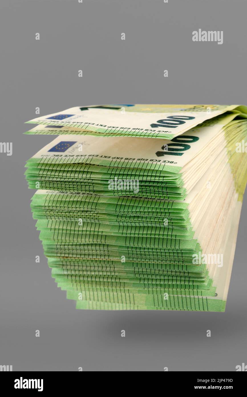 A large stack of 100 euro banknotes on a uniform gray background. Stack ...