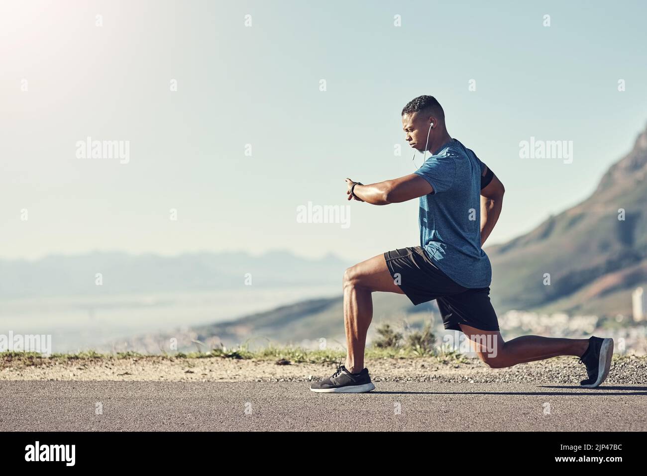 Timing his lunges. a young handsome man doing lunges outdoors Stock ...