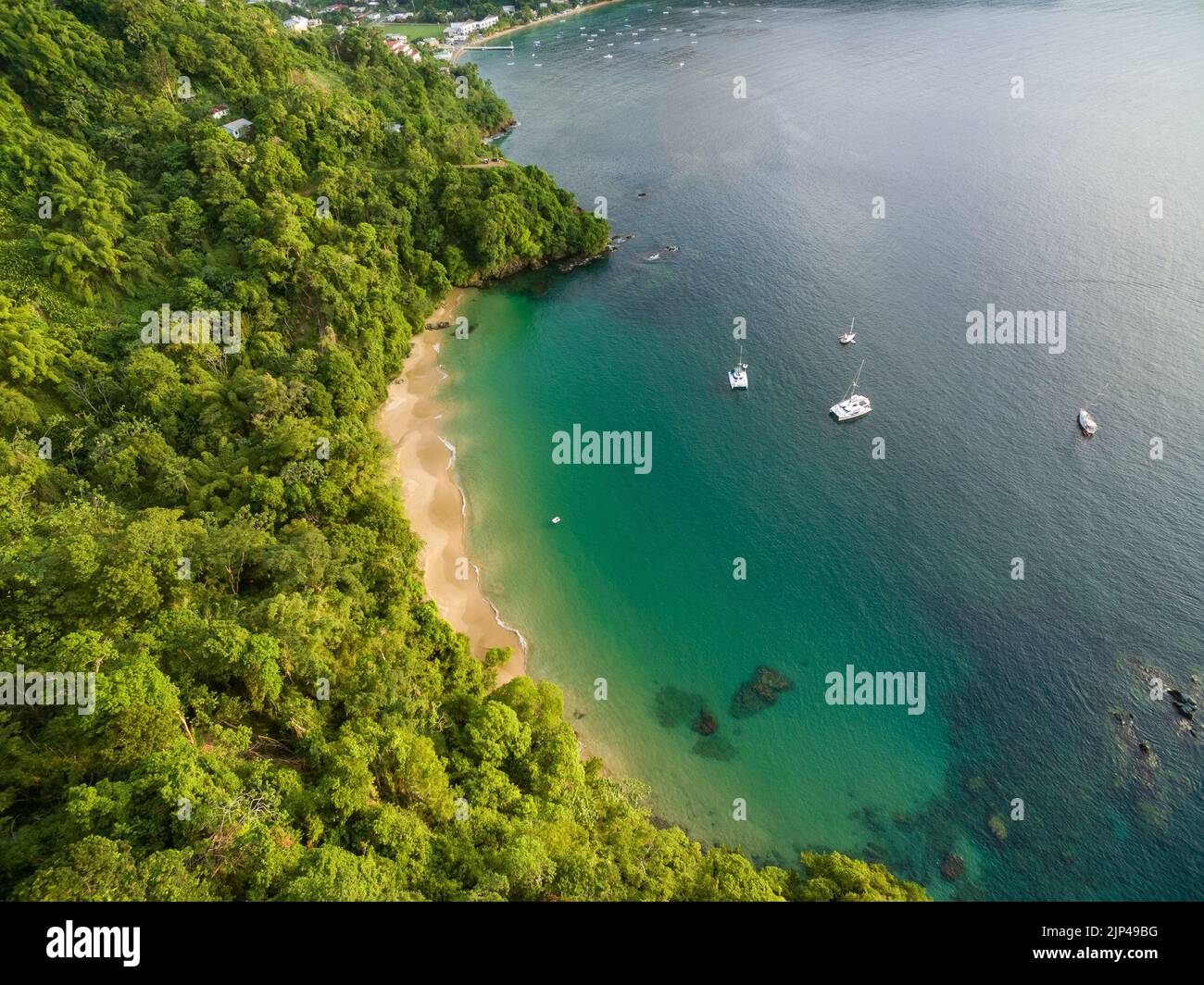 Areal of yachts anchoring in Caribbean bay with beach and forest. This ...