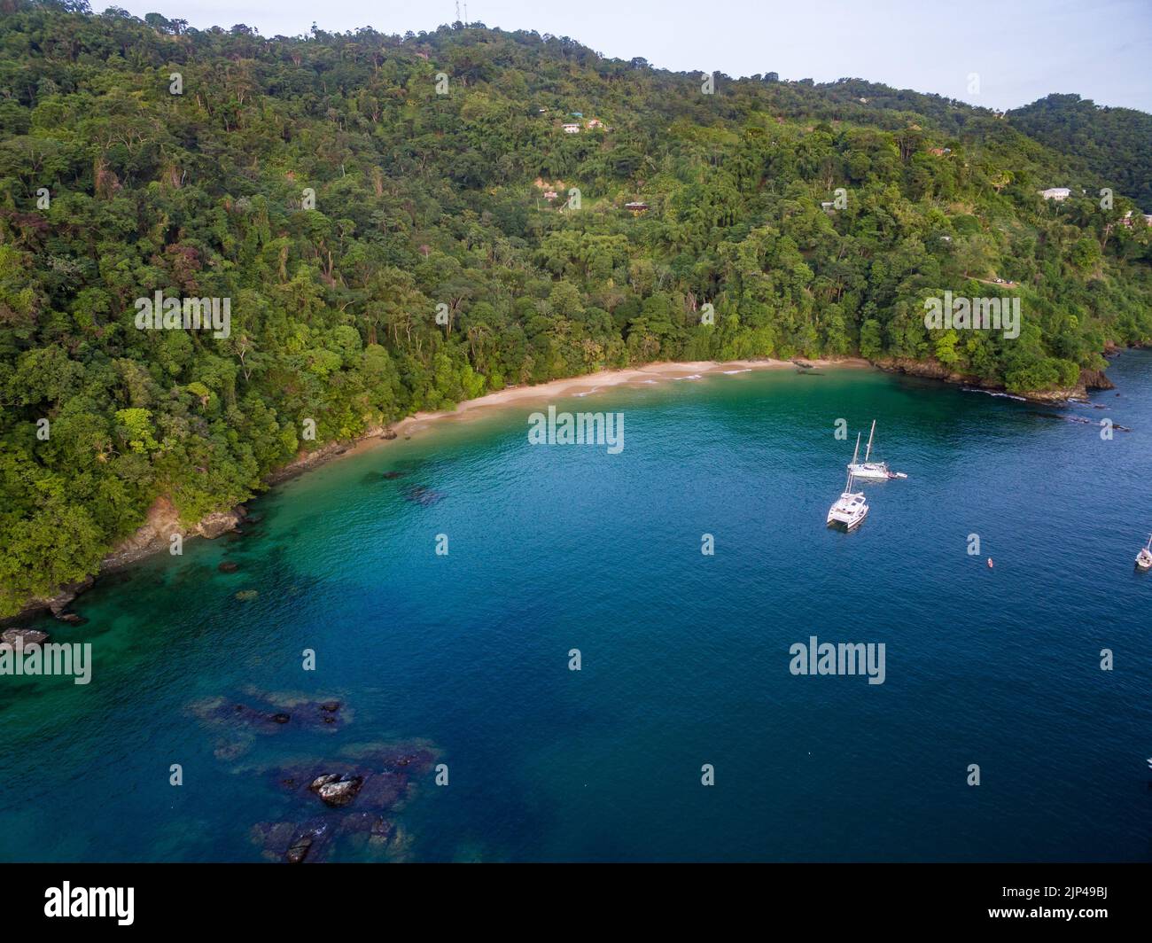 Yachts anchoring in Caribbean bay with beach and forest in the ...
