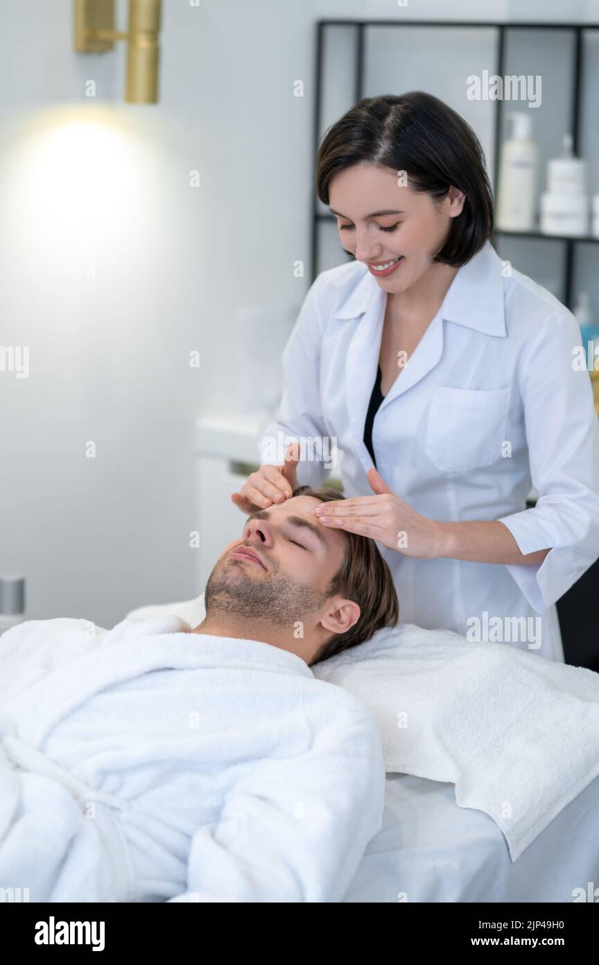 Female professional doing face massage to a male client Stock Photo - Alamy