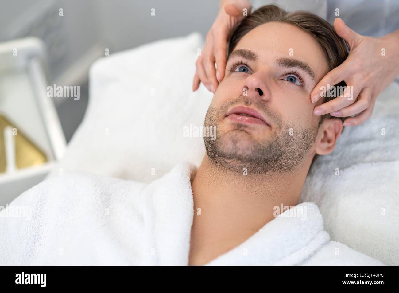 Young male client having face massage in a professional salon Stock ...